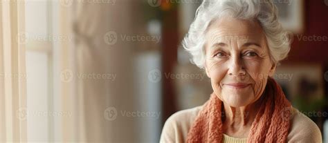 86 Year Old Woman Alone At Home Standing By Window In Apartment Wearing Beige Cardigan 27183916