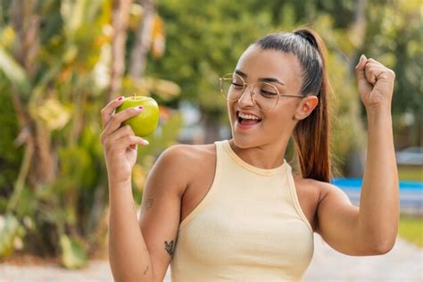 Premium Photo Young Pretty Woman With An Apple At Outdoors
