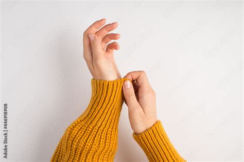 First Person Photo Of Womans Hands Pulling On Sleeve Of Yellow Sweater