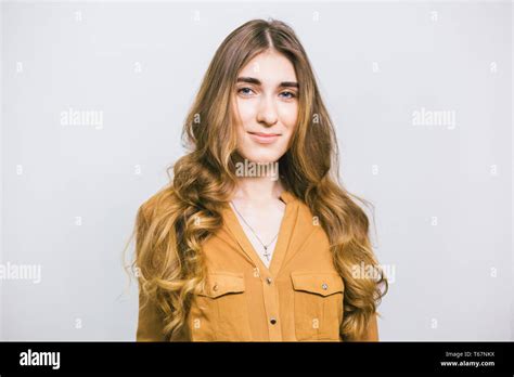 Portrait Of A Beautiful Young Woman With Long Curly Hair On A Plain