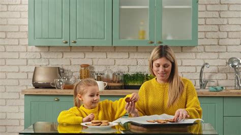 Mother And Daughter Together In The Kitchen Mom Teaching Girl How To