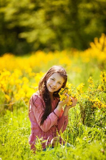 Premium Photo Smiling Girl Sitting In The Field Of Spring Yellow Flowers