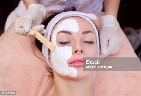 의사는 뷰티 살롱에서 젊은 여자의 얼굴에 막대기로 마스크를 적용 하는 클렌징과 피부 보습의 절차에 대 한 미용사 가꿔주기에 대한 스톡 사진 및 기타 이미지 Istock
