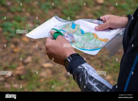 Man Holding A Map And The Compass During Orienteering Competitions