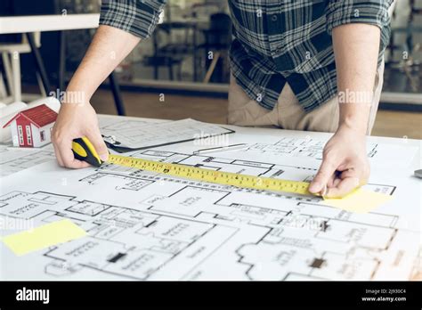 Architects Are Working On A New Project While Using A Tape Measure