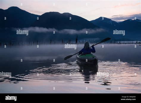 Adventurous Girl Kayaking On An Infatable Kayak In A Beautiful Lake