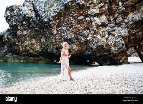 Beautiful Blonde Woman Standing At Milopotamos Beach In Greece Stock