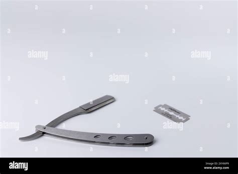 An Open Barbers Straight Razor With A Gleaming Blade Set Against A