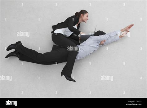 Two Businesss People Woman Riding On Mans Back Side View Elevated