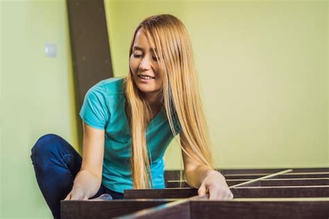 Premium Photo Caucasian Woman Using Screwdriver For Assembling Furniture