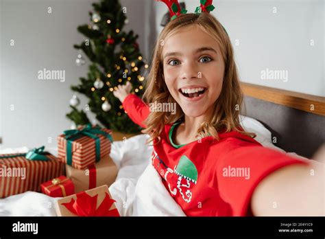 Excited Caucasian Girl Wearing Toy Deer Horns Taking Selfie On