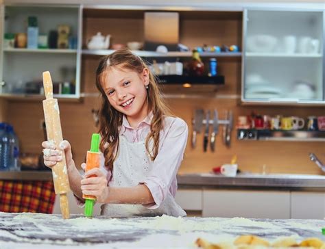Menina Alegre Cozinhando Massa Na Cozinha Foto Grátis