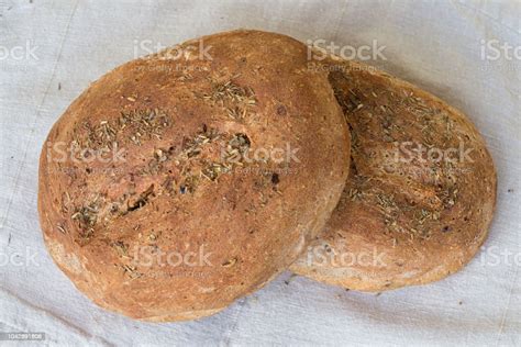 수 제 두 빵 빵 식탁보에 누워 아로마 허브와 함께 신선한 향기로운 빵입니다 밝은 배경에 빵의 전체 덩어리 갈색에 대한 스톡