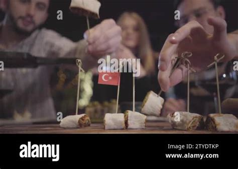 Hands Of Blurred People Taking Pieces Of Kebab Rolled In The Pita Lying