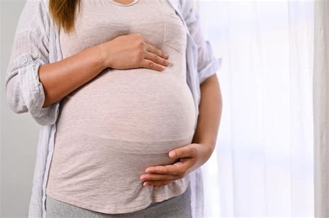 Premium Photo A Pregnant Woman Touching Her Big Belly With Love And