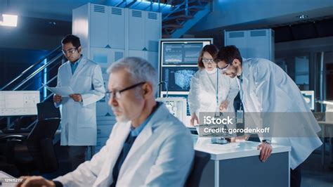 연구 실험실에서 중장비 설계작업 흰색 코트를 입고 산업 과학자 및 엔지니어의 다양한 국제 팀 3d 프린터 컴퓨터 및 현미경을