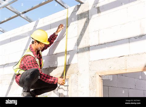Construction Worker Or Contractor Man Using Measuring Tape Checking From Steel Roof Frame To The