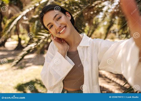 Cute Young Caucasian Girl With Toothy Smile Takes Selfie Outdoors
