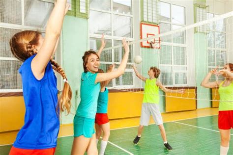 Έφηβη που πιάνει τη σφαίρα κατά τη διάρκεια της αντιστοιχίας πετοσφαίρισης Στοκ Εικόνες εικόνα