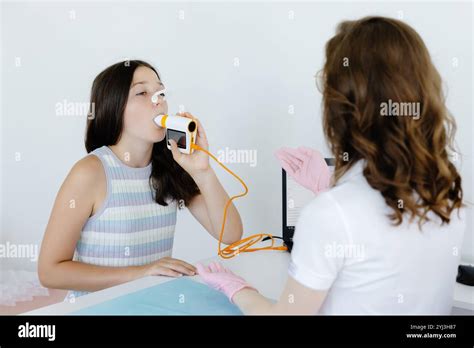 Girl Testing Breathing Function By Spirometry In Doctors Office