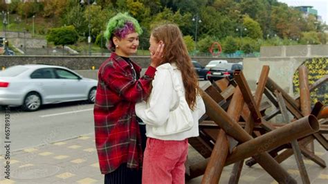 Two Lesbian Girls Couple Kissing In Front Of Antitank Hedgehogs In Kyiv