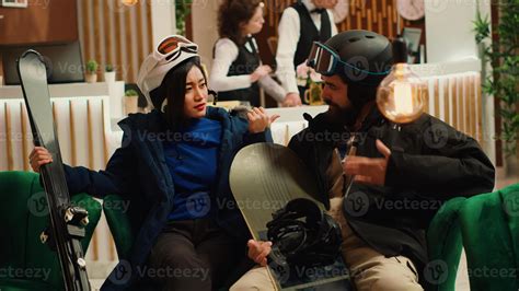 Diverse Couple With Sport Equipment Resting On Couch After Skiing