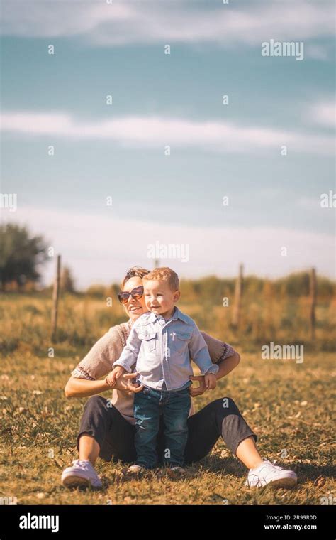 A Loving Mother And Her Son Embrace In A Sun Kissed Field Radiating