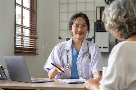 Doctor Or Physician Writing Diagnosis And Giving A Medical Prescription To Male Patient Stock