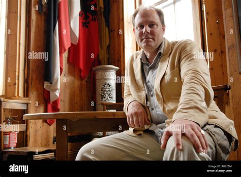 Vaughan Smith Sits In Front Of Flags From Various Wars At The Frontline