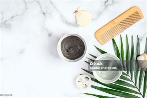 대리석 배경에 열대 야자수 잎 머리 빗 수세미 스폰지와 조개와 녹색과 검은 얼굴 점토 마스크 얼굴 이나 헤어 트리트먼트 스킨