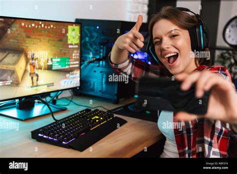 Excited Girl Gamer Sitting At The Table Playing Online Games On A