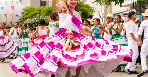 People In Costumes Dancing On A Street During The Guelaguetza Festival