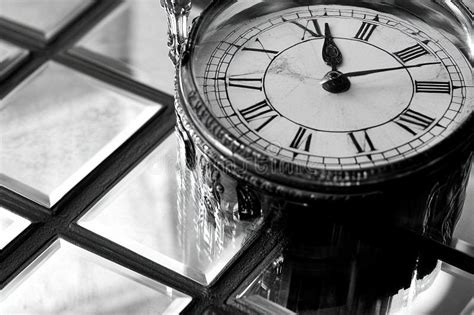 A Vintage Clock Reflecting On A Glass Surface Captures The Passage Of