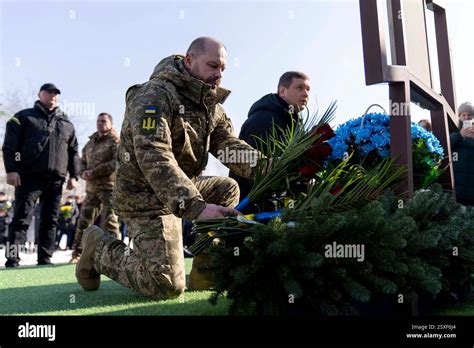 Soldier Laying Down Flowers At Ceremony Honoring Killed Civilians At
