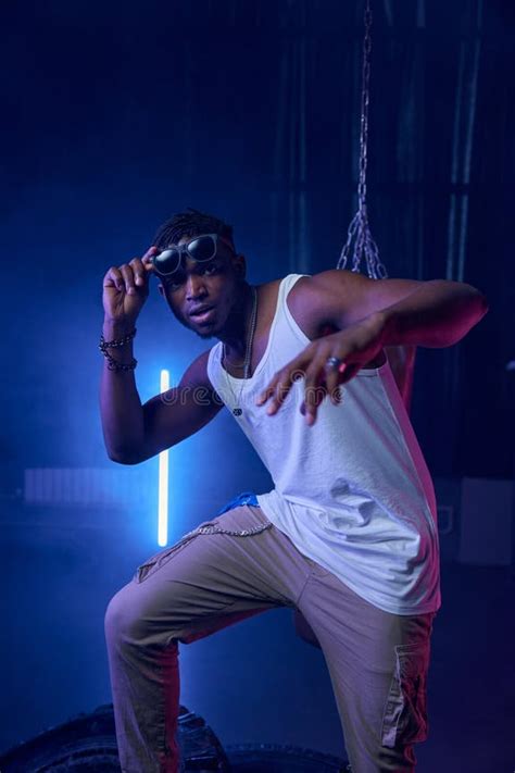 Fashion Muscular Rapper Standing In Neon Lights Of Cool Nightclub Stock