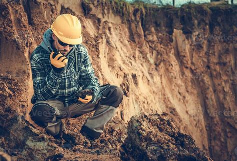 Caucasian Male Engineering Geologist Talking On Radio At Construction