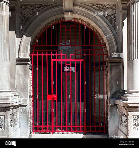 Red Wrought Iron Gate With Geometric Design Set Within A Grand Arched