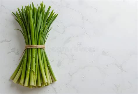 A Fresh Bundle Of Lemongrass Tied Together With Natural Twine Resting On A Clean White