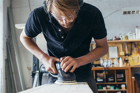 Carpentry Portrait Of Young Carpenter Sanding Wood Plank With Random