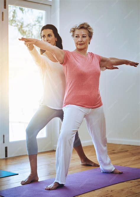 Premium Photo Mature Woman And Yoga Instructor Helping With Warrior