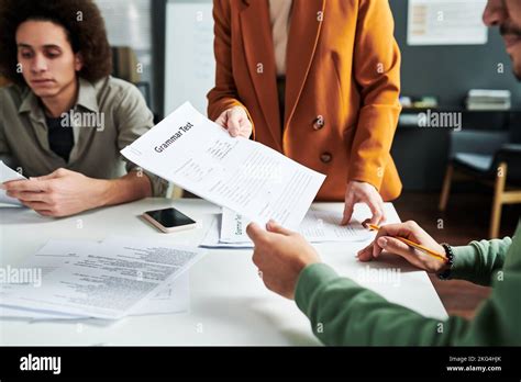 Document With English Grammar Test Being Passed By Teacher To One Of