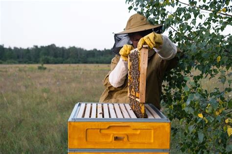 Premium Photo A Beekeeper A Woman In A Protective Suit Against Bee