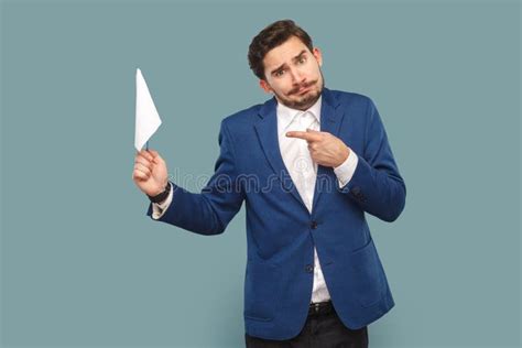 Stressed Man Standing And Pointing At White Flag Looking At Camera With Frowning Face Stock
