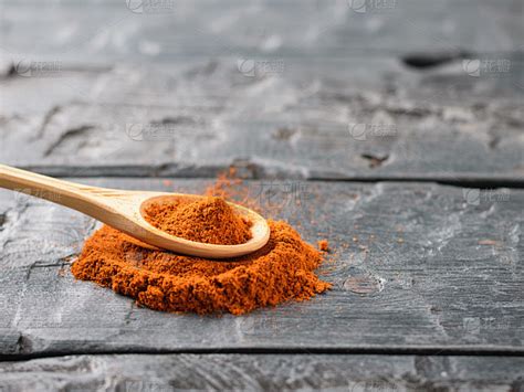 用勺子在木桌上舀上少量的红辣椒。