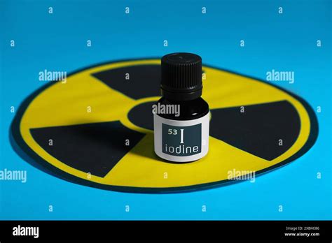 Bottle Of Medical Iodine And Radiation Sign On Light Blue Background