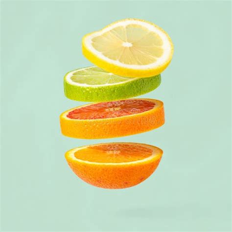 Floating Citrus Fruit Slices On Pastel Green Background Stock