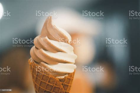 Hand Holding A Two Tone Chocolate And Vanilla Ice Cream Waffle Close Up