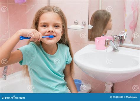 Sex åriga Flicka Som Borstar Hennes Tänder Och Vänder I Väg Från Vasken Ser I Bilden