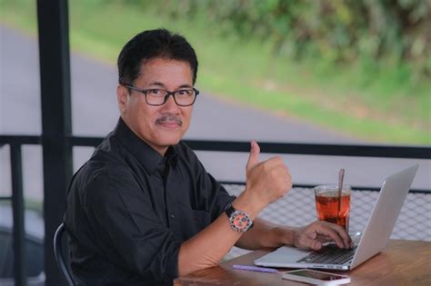 Premium Photo Man Raising His Thumb Up While Working On His Laptop At