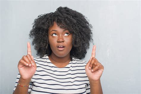 젊은 아프리카계 미국인 플러스 크기 여자 회색 그런 지에 깜짝 놀라게 하 고 놀 보고 하 고 손가락으로 가리키는 벽 하 고